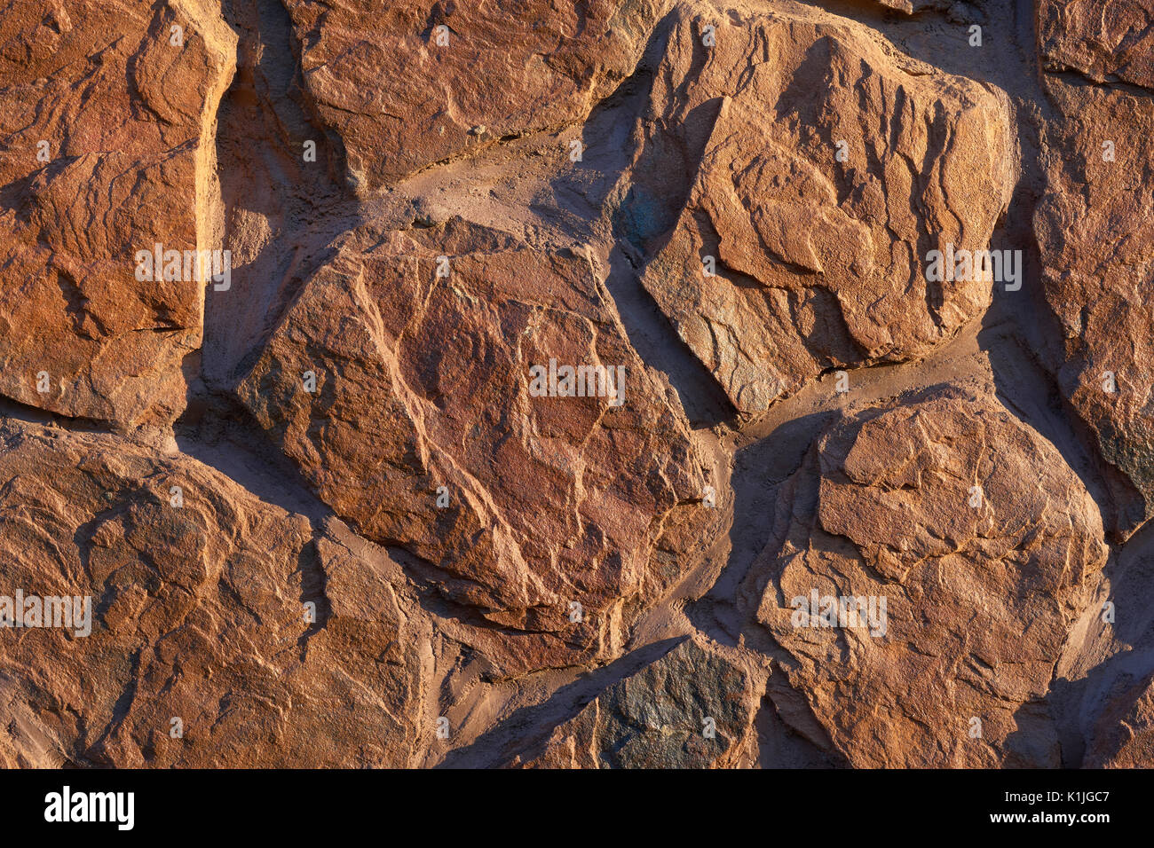 Red stone textured finishing on the foundation of the house Stock Photo ...
