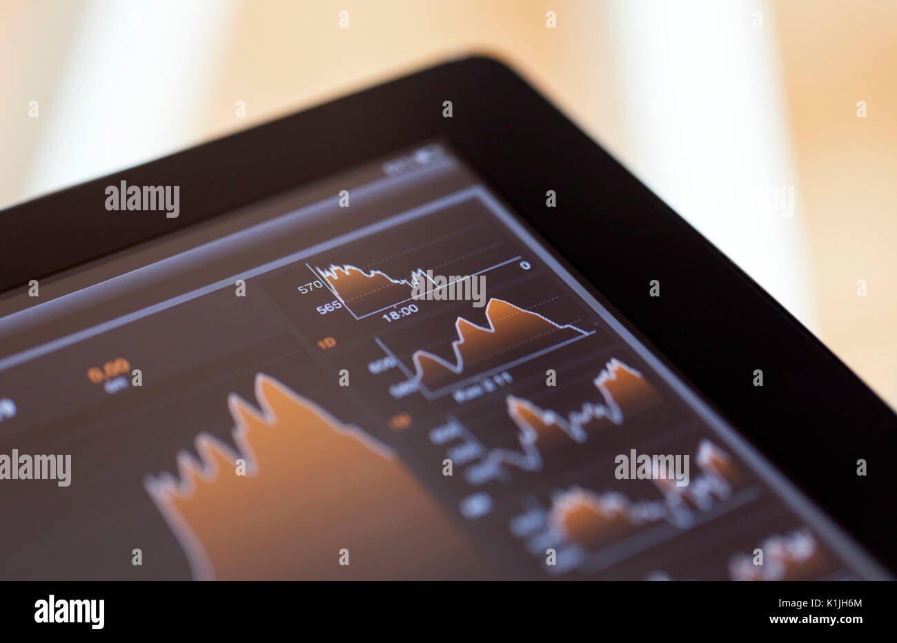 Analyzing stock market from a digital tablet over a detailed diagram ...