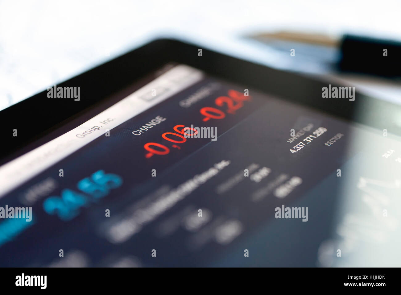 Analyzing stock market from a digital tablet over a detailed diagram ...