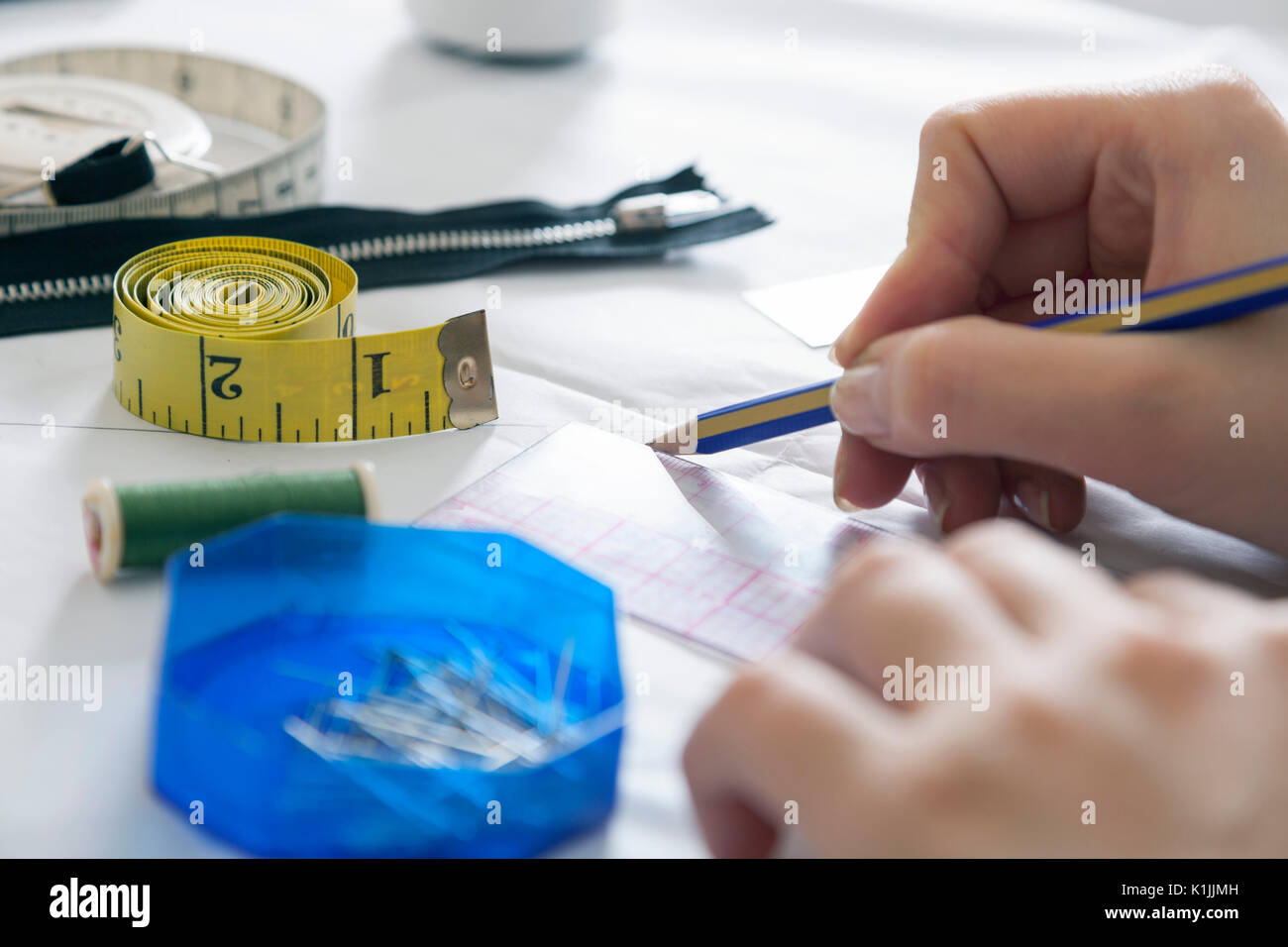 Female fashion designer or student is designing and sketching her new ...