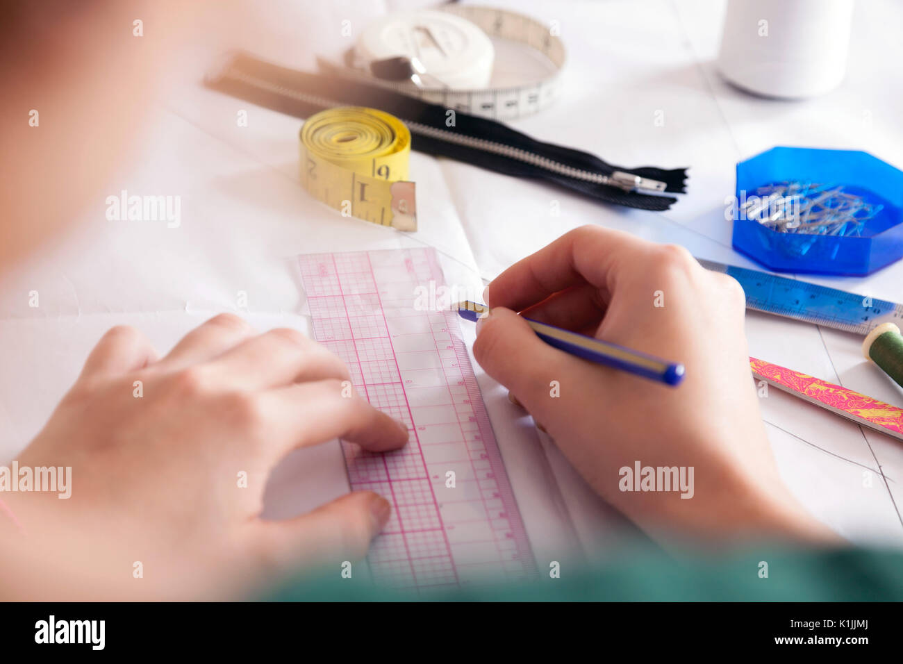 Female fashion designer or student is designing and sketching her new ...