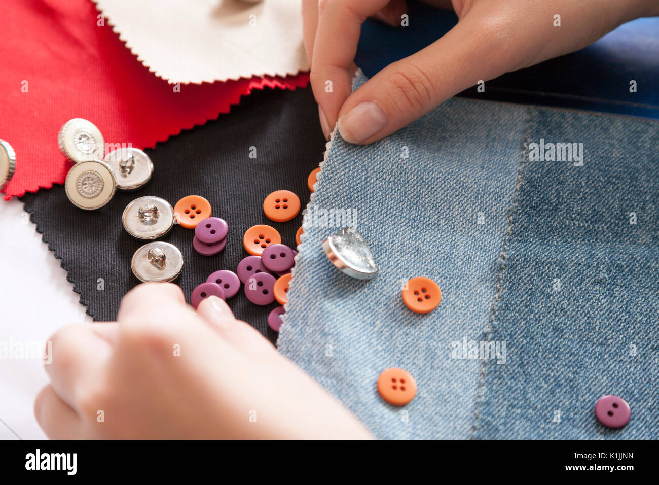 Female fashion designer is selecting buttons for her new dress Stock ...