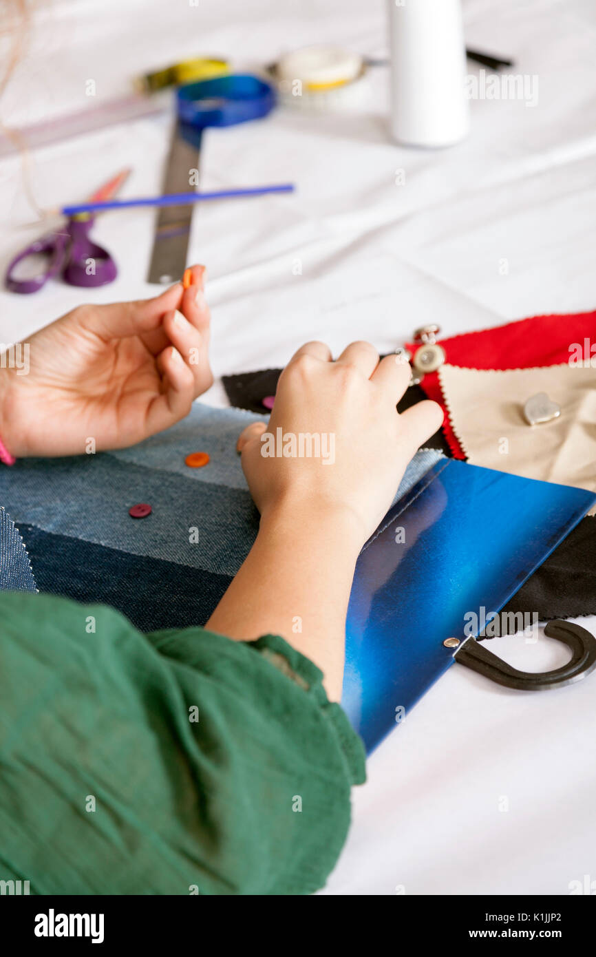 Female fashion designer is selecting buttons for her new dress Stock ...