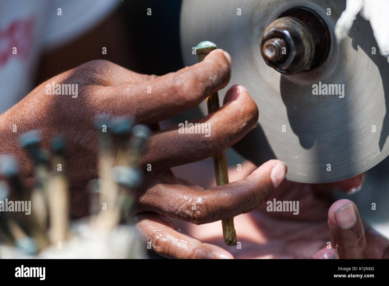 A close-up of hands polishing a piece of jade, Jade Market, Mandalay ...