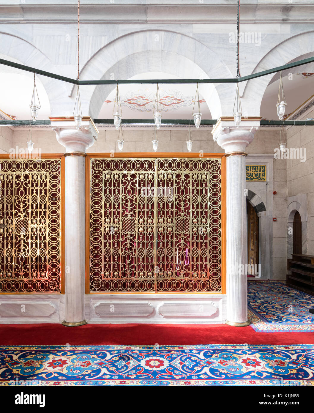 Golden ornate perforated partition framed in white marble arch and ...