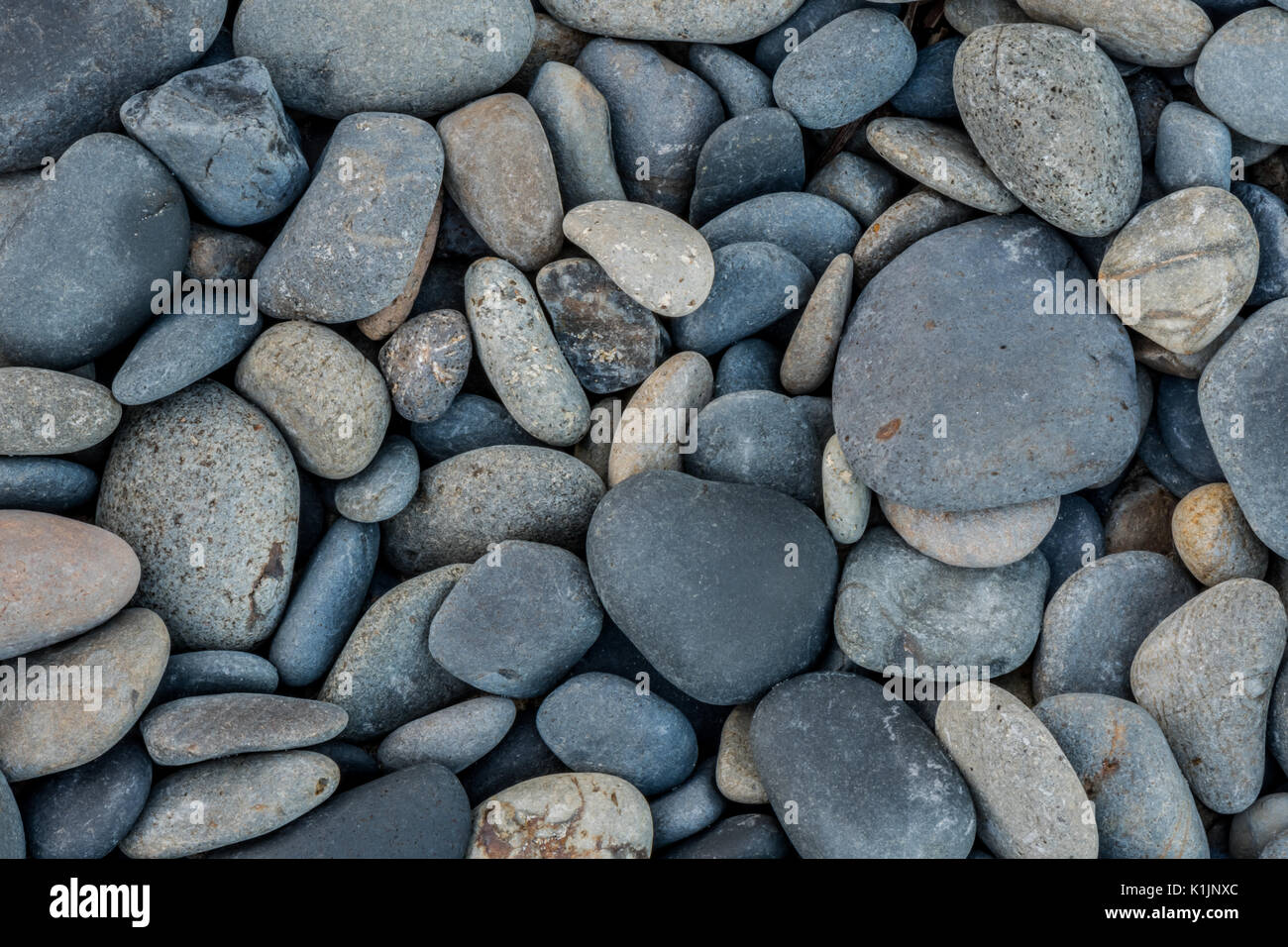Wide view of smooth beach rocks background image Stock Photo - Alamy