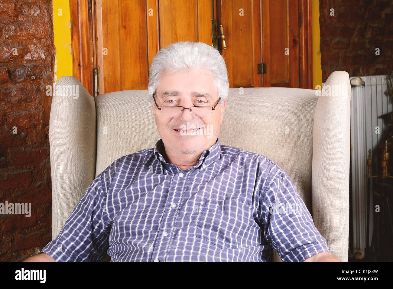Portrait of an elderly man sitting on couch. Indoors Stock Photo - Alamy