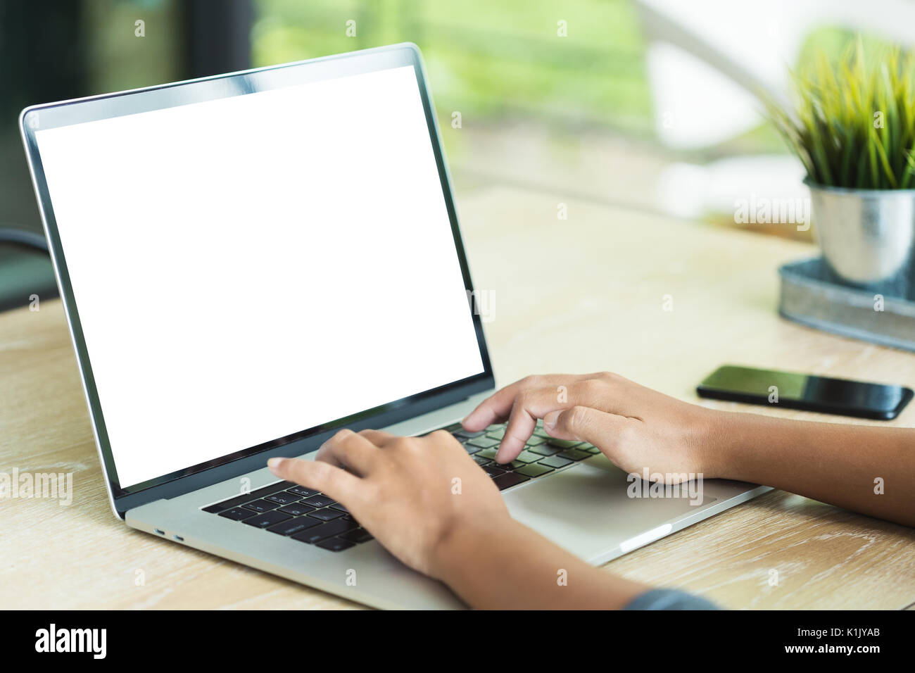 hand typing laptop computer showing blank screen on table office place ...