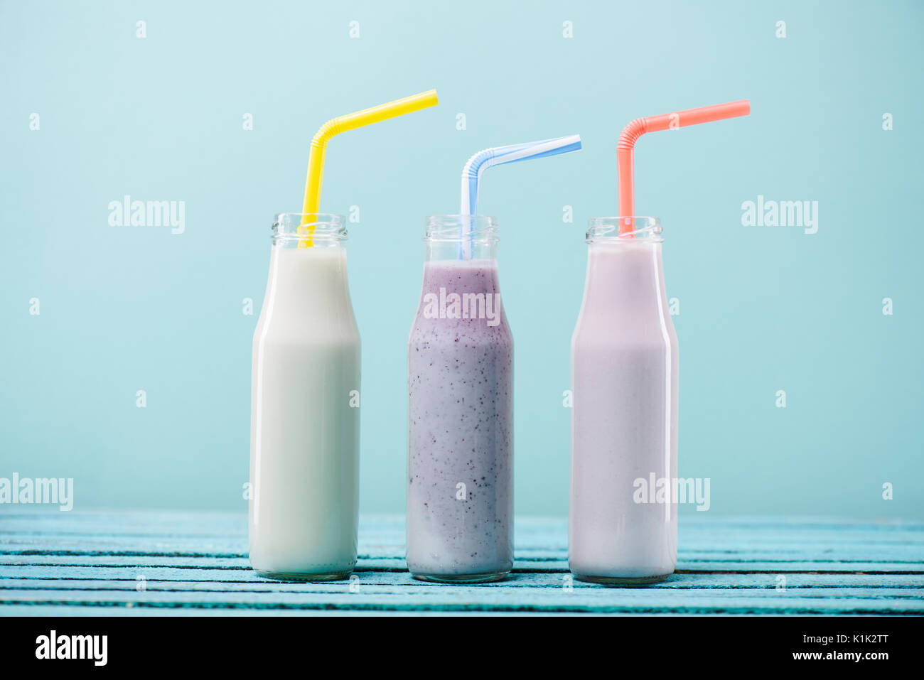 homemade fruity milkshakes in glass bottles with straws on tabletop on ...