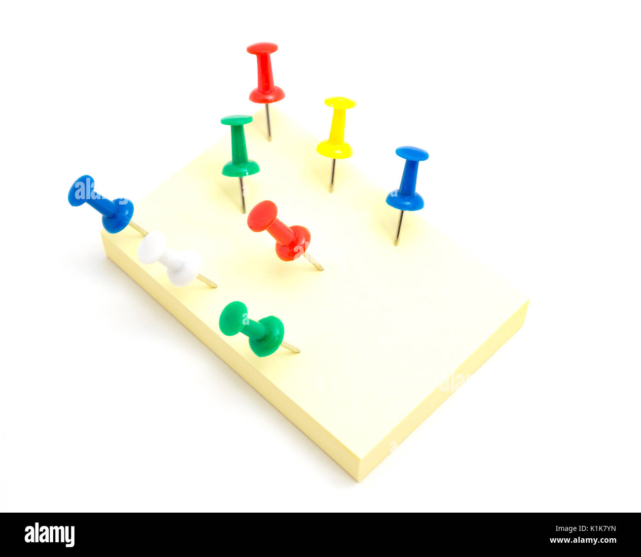 Eight push pins and yellow sticky note on isolated white background ...