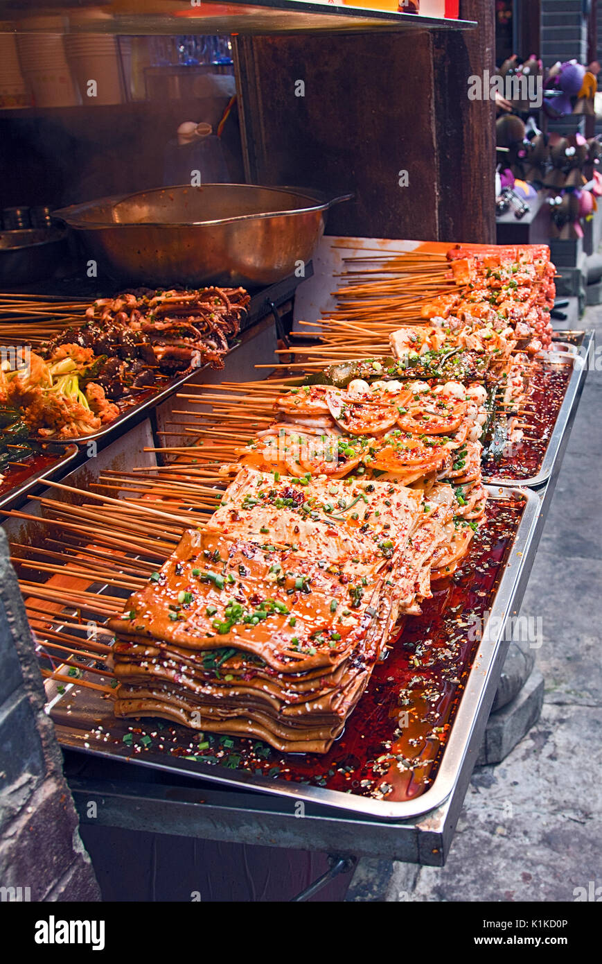 Numerous bits of skewered food, including squid, bugs, tofu, and ...