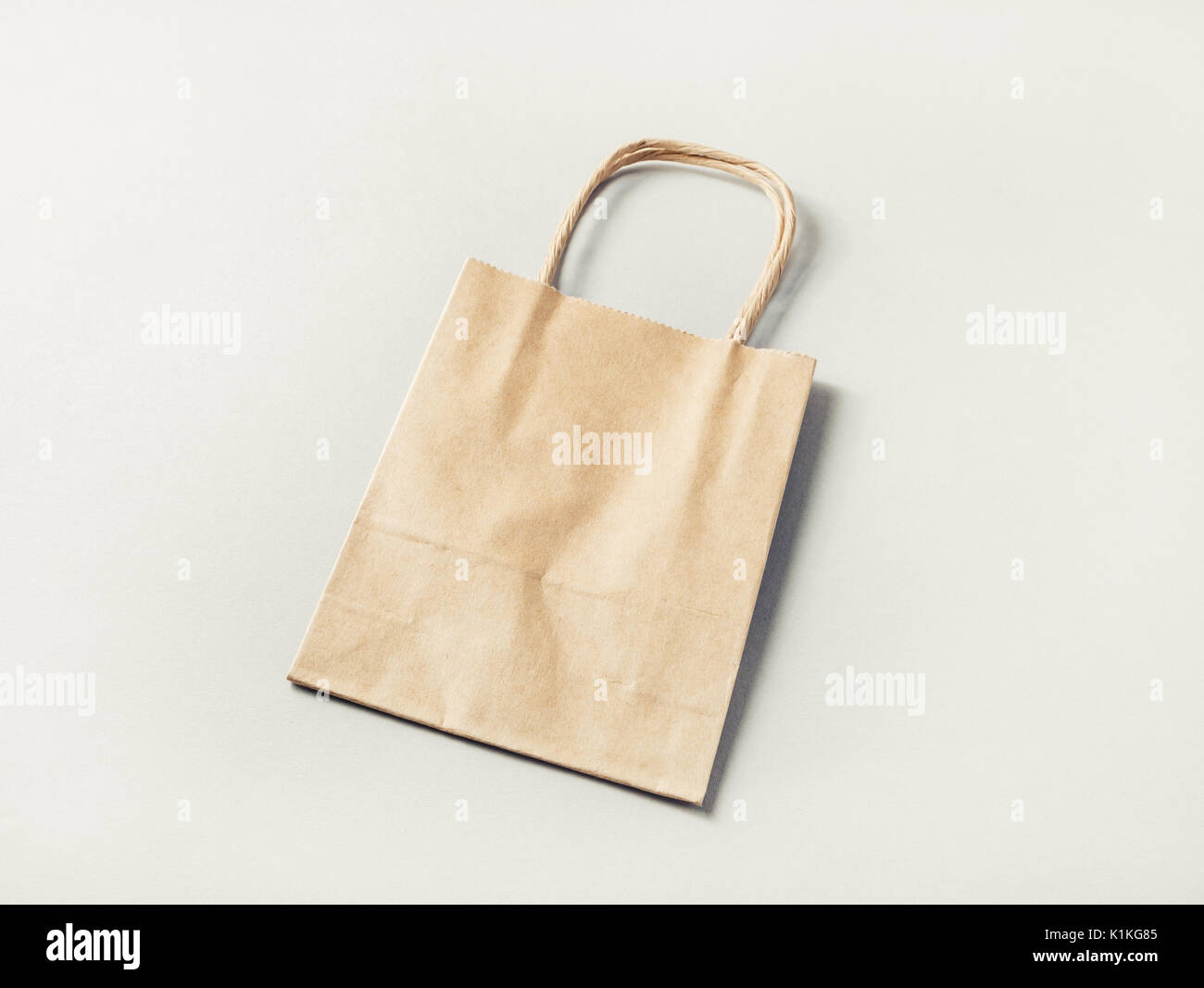 Paper shopping bag on paper background. Craft paper package Stock Photo ...