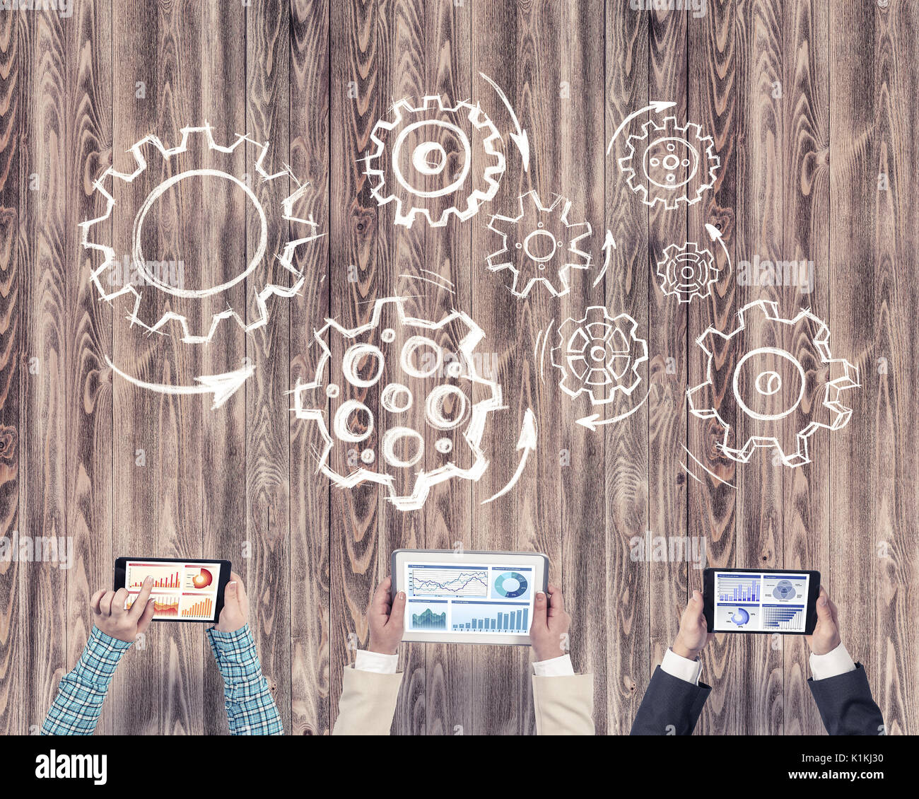 Group of three people with devices in hands working together as symbol ...