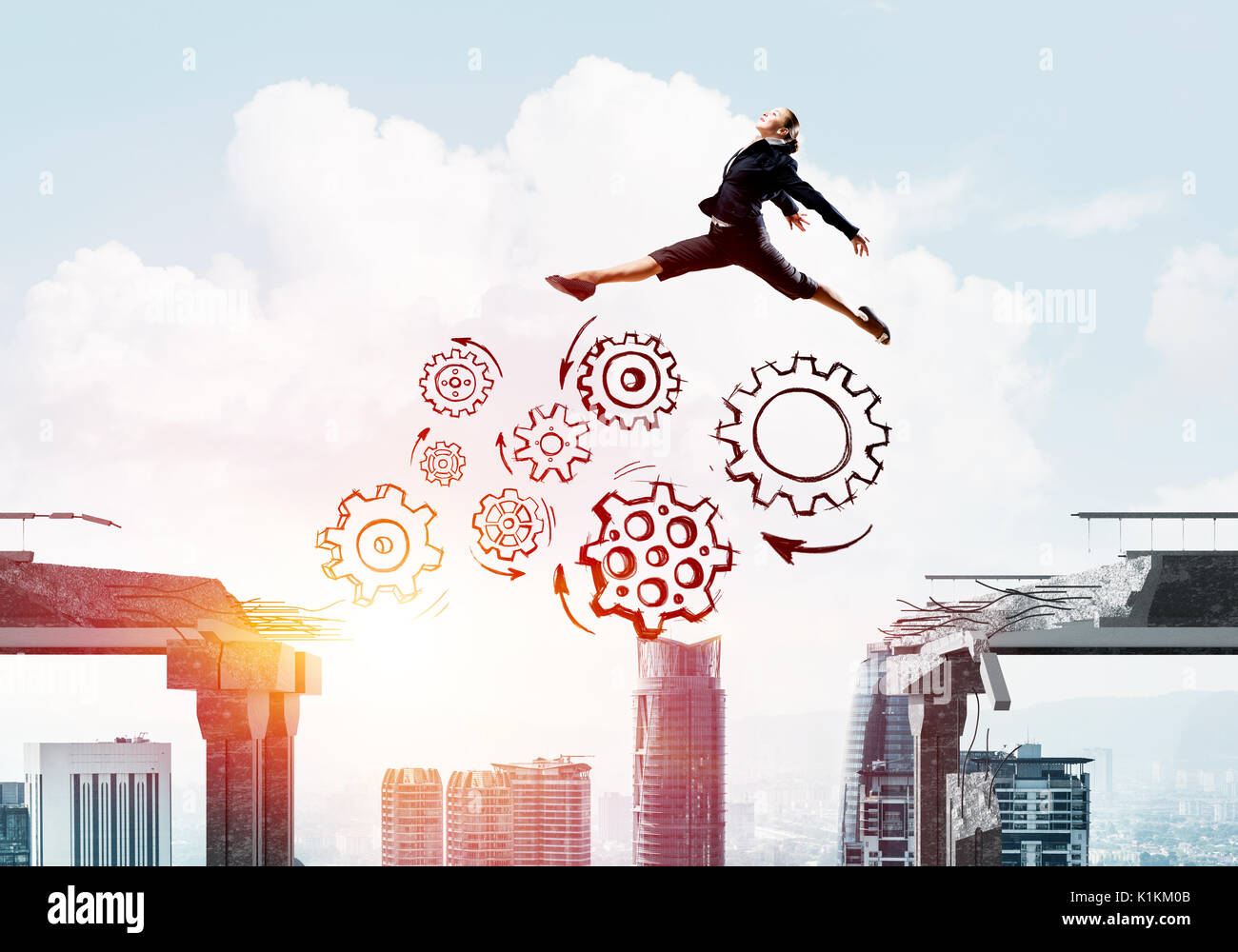 Business woman jumping over gap with gear mechanism in concrete bridge ...