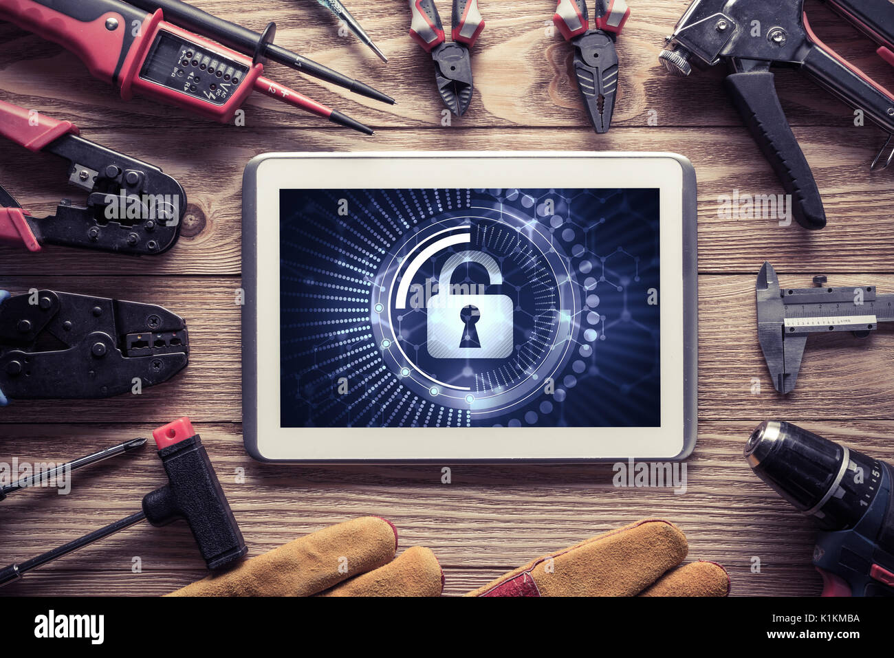 Tablet pc with security concept on screen and industrial tools around ...