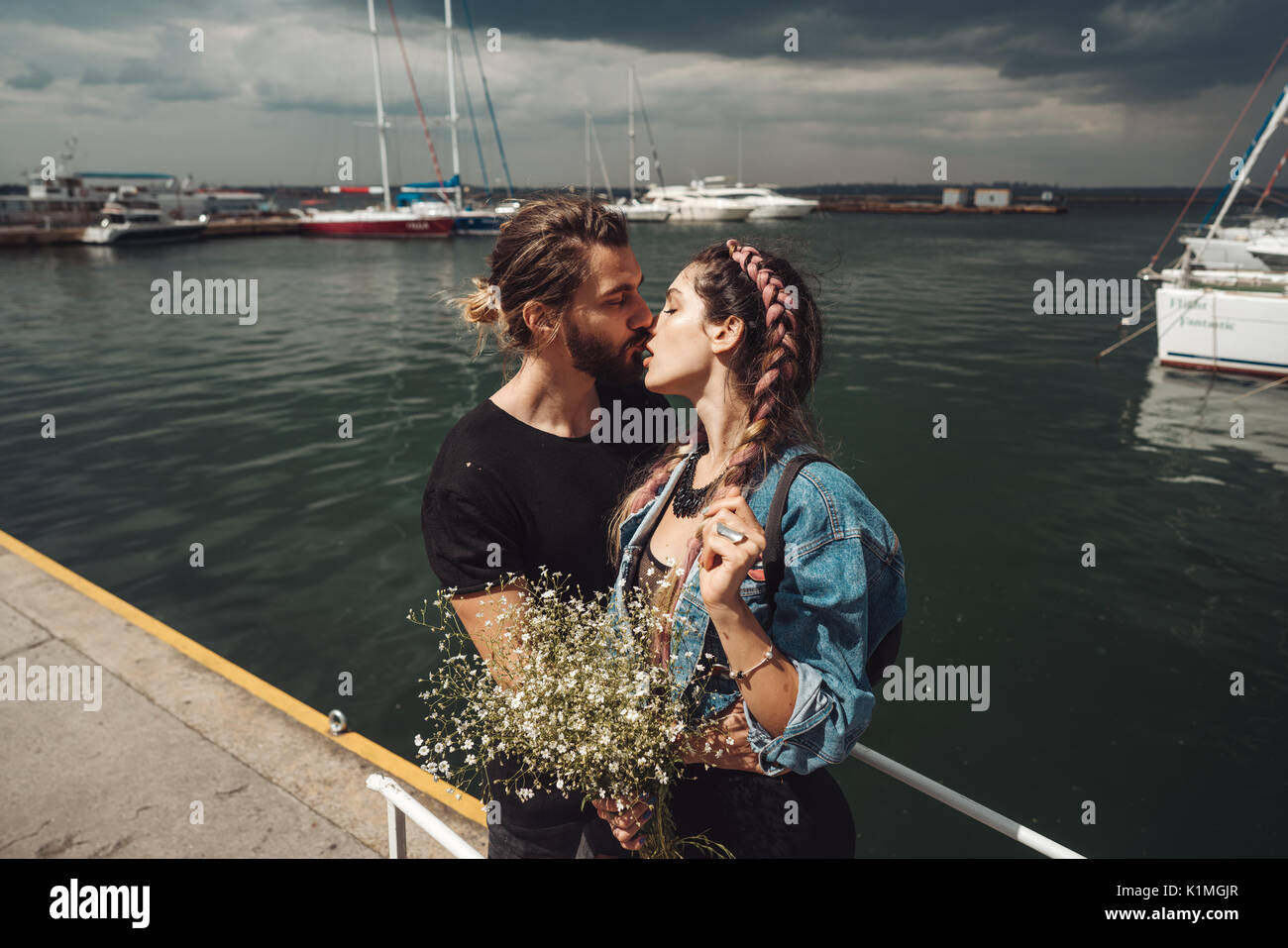 Guy and girl on pier posing on camera Stock Photo - Alamy