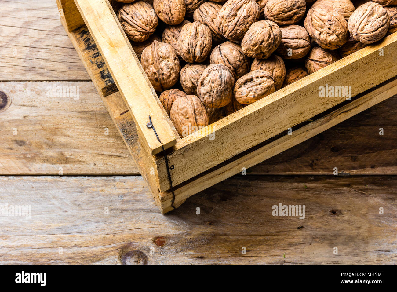 Box of walnuts on wooden background. Harvest concept Stock Photo - Alamy