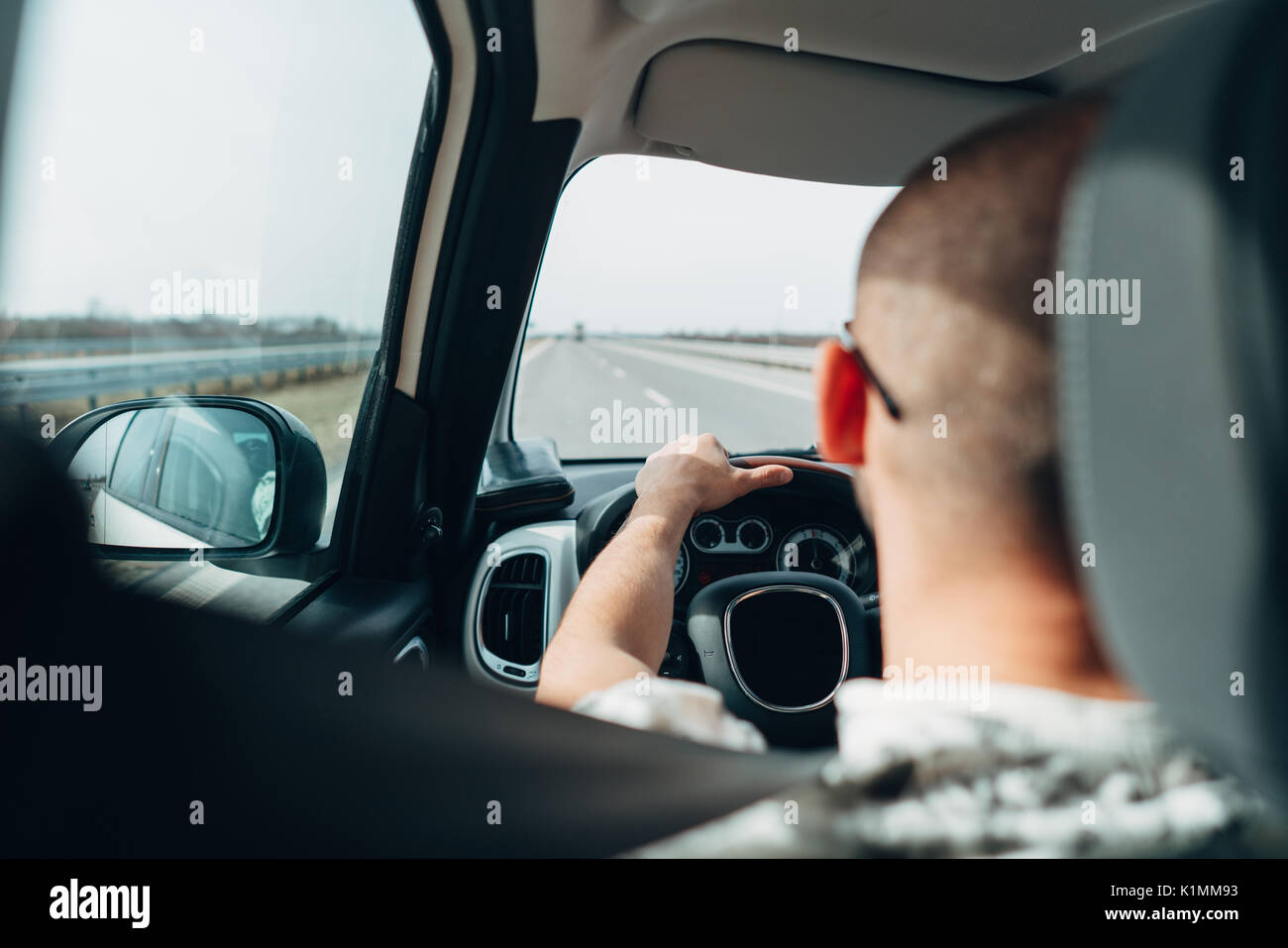 The man behind the wheel of a car traveling on the road Stock Photo - Alamy