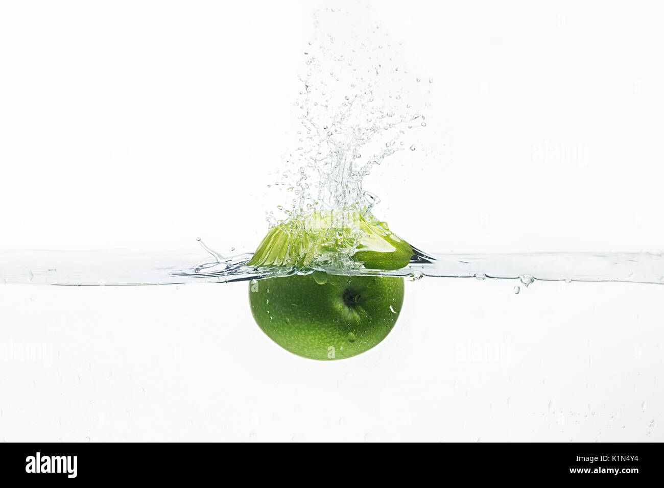 Green apple thrown in water shot Stock Photo - Alamy
