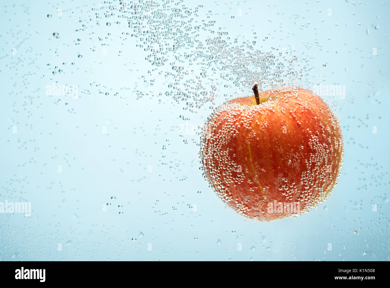 Sweet red apples floating in water shot Stock Photo - Alamy