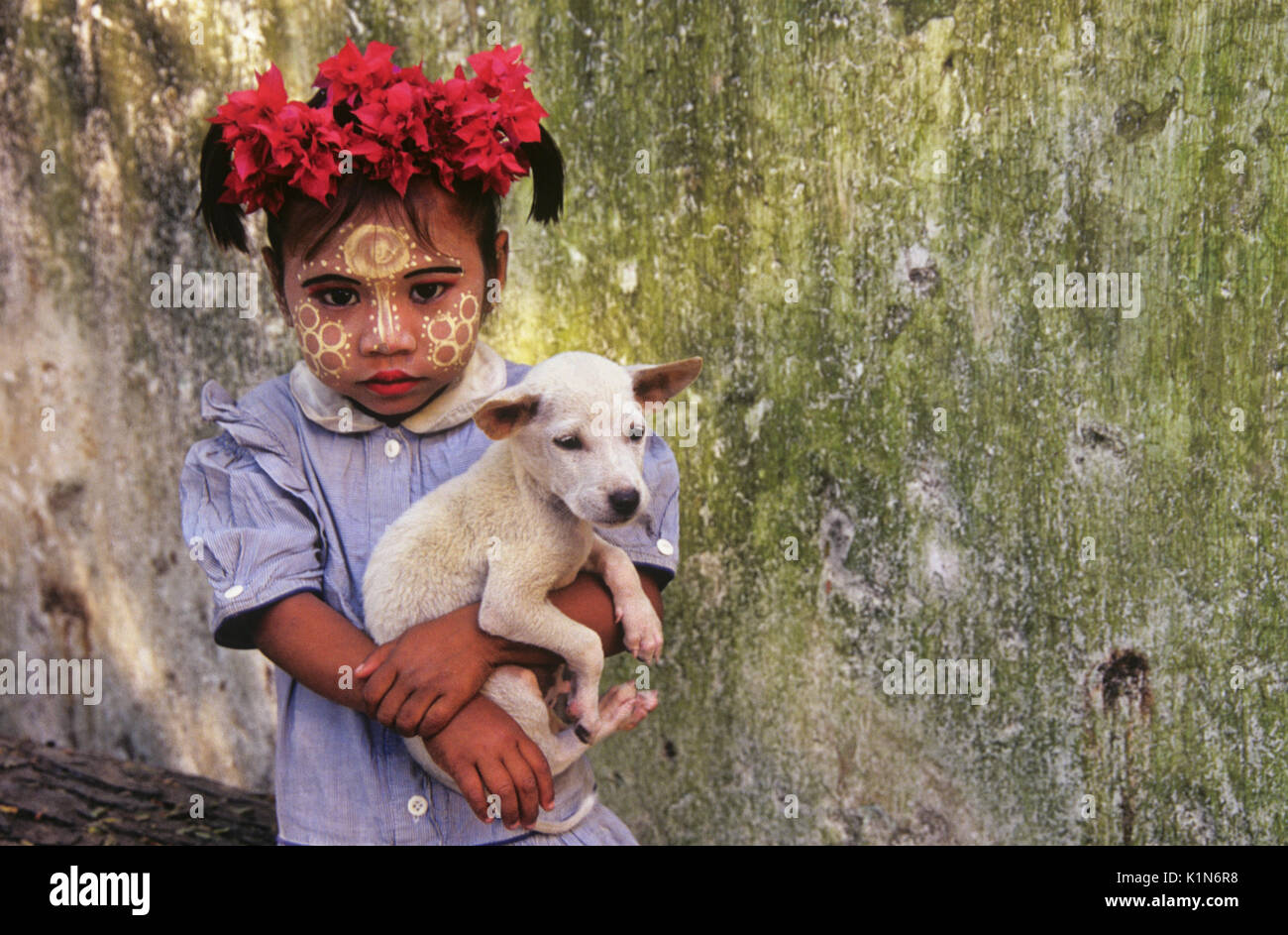 Little girl (thanaka designs on face) with puppy, Amarapura, Mandalay ...
