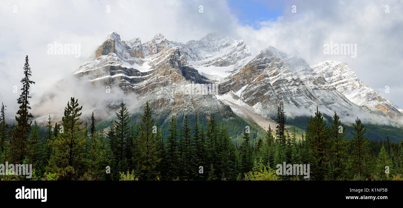 High mountains of the Canadian Rockies surrounded by clouds along the ...