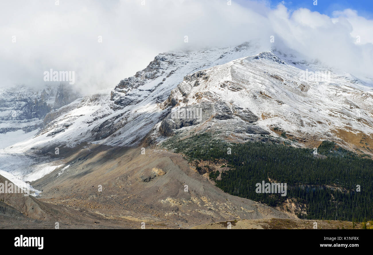 High mountains of the Canadian Rockies surrounded by clouds along the ...