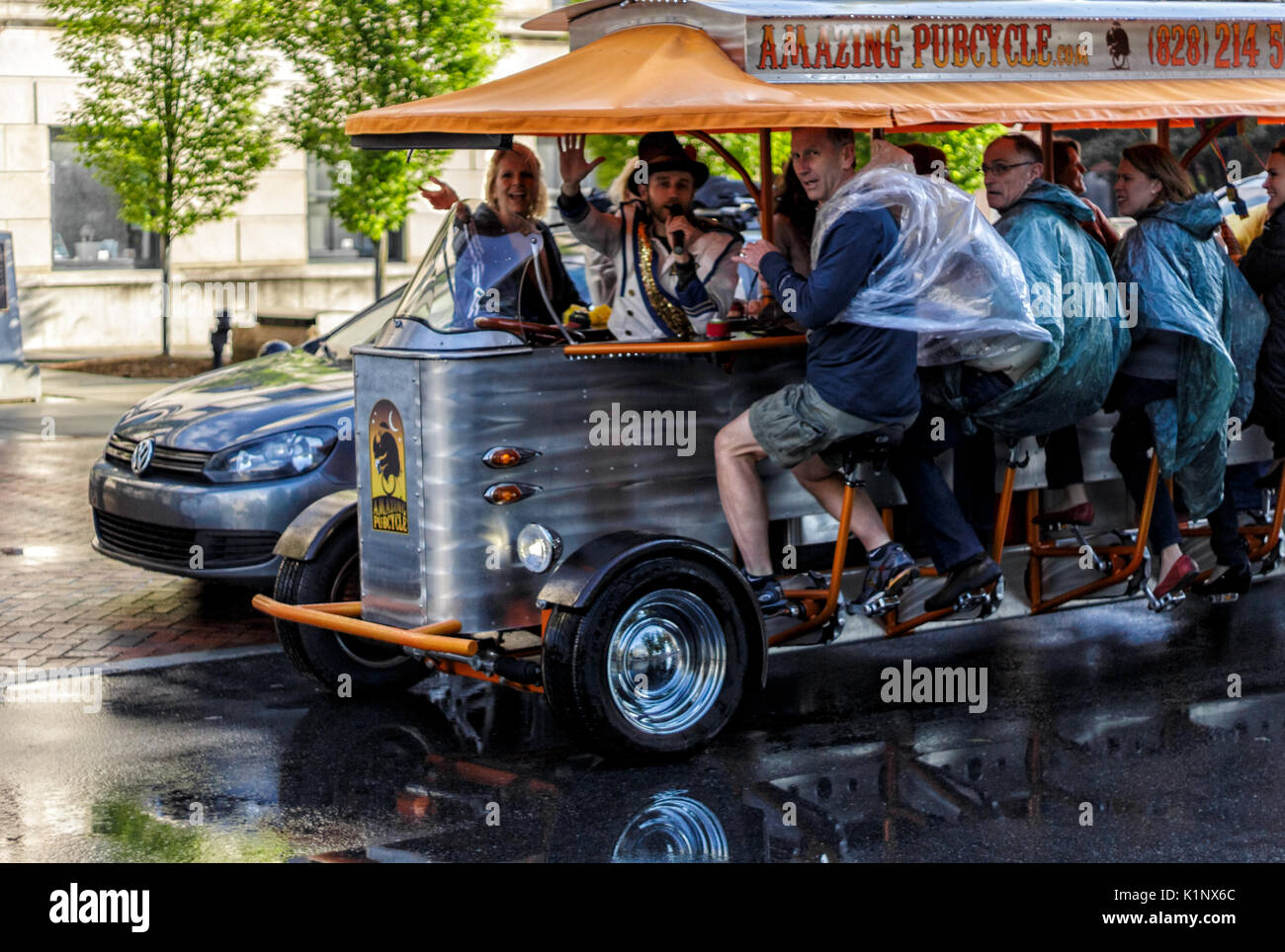 A trolley on wheels with beer drinkers, on a downtown tour, wave at the ...