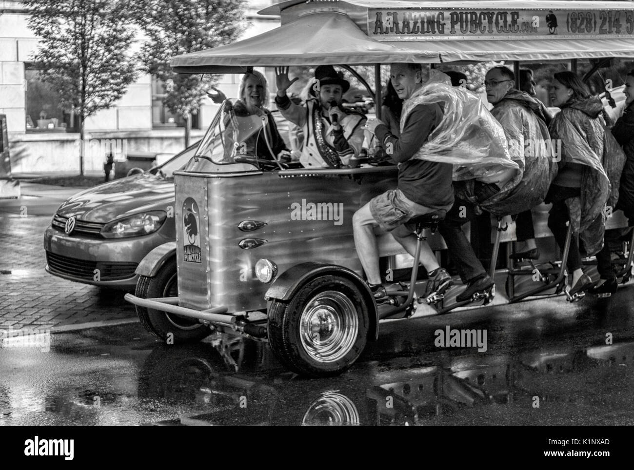 A trolley on wheels with beer drinkers, on a downtown tour, wave at the ...