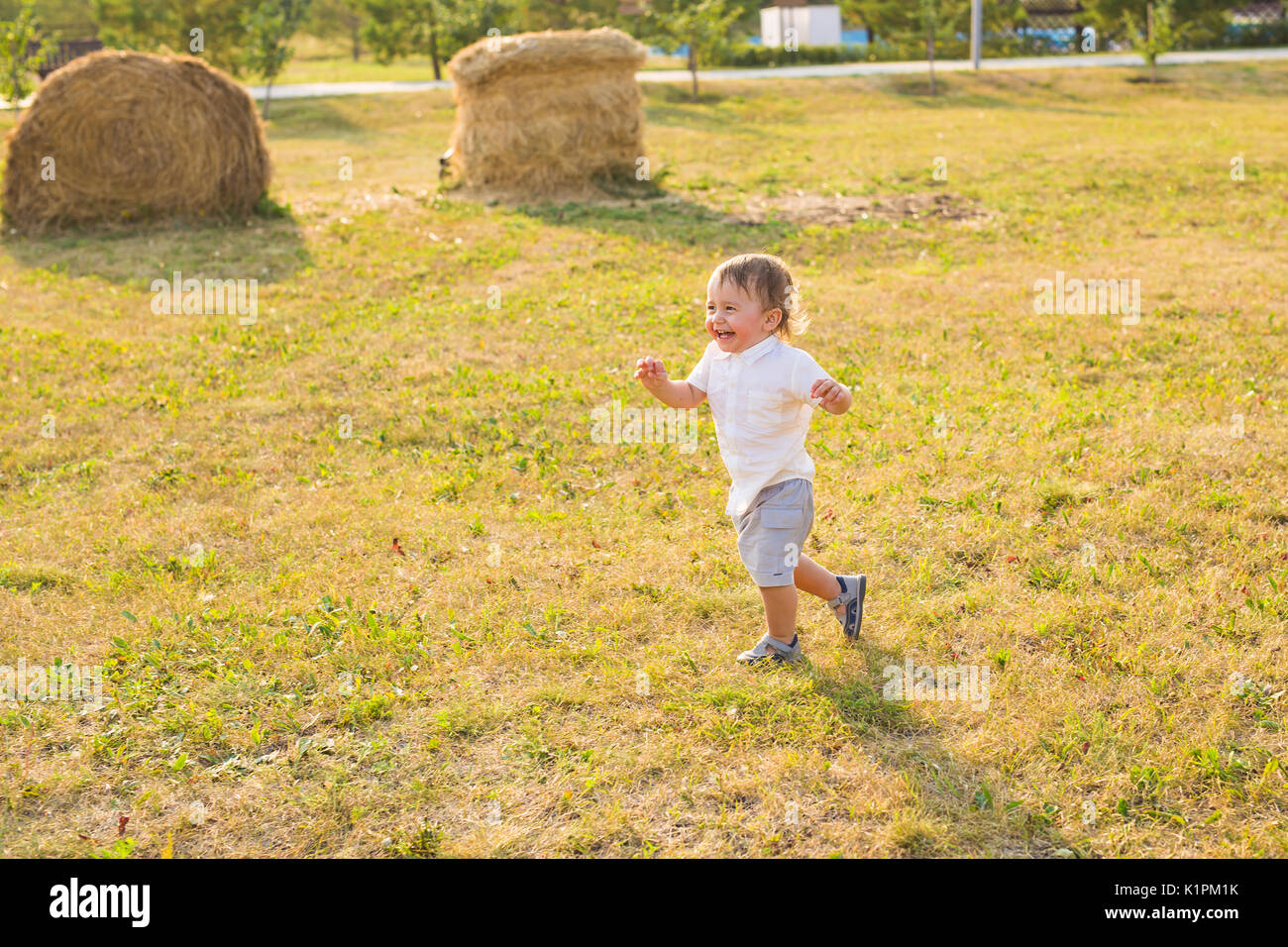Happy laughing baby boy running on summer or autumn field Stock Photo ...