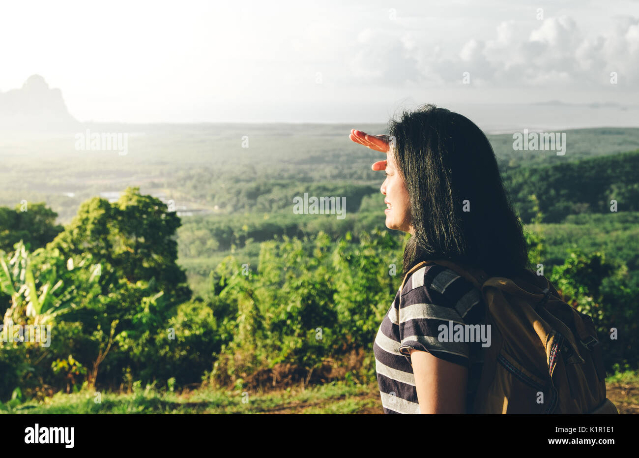 young traveler backpacker looking forward at sun to see landscape view ...