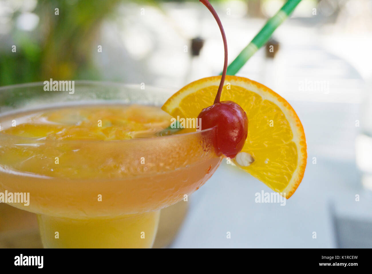 Tropical cocktail with orange and cherry garnish Stock Photo - Alamy