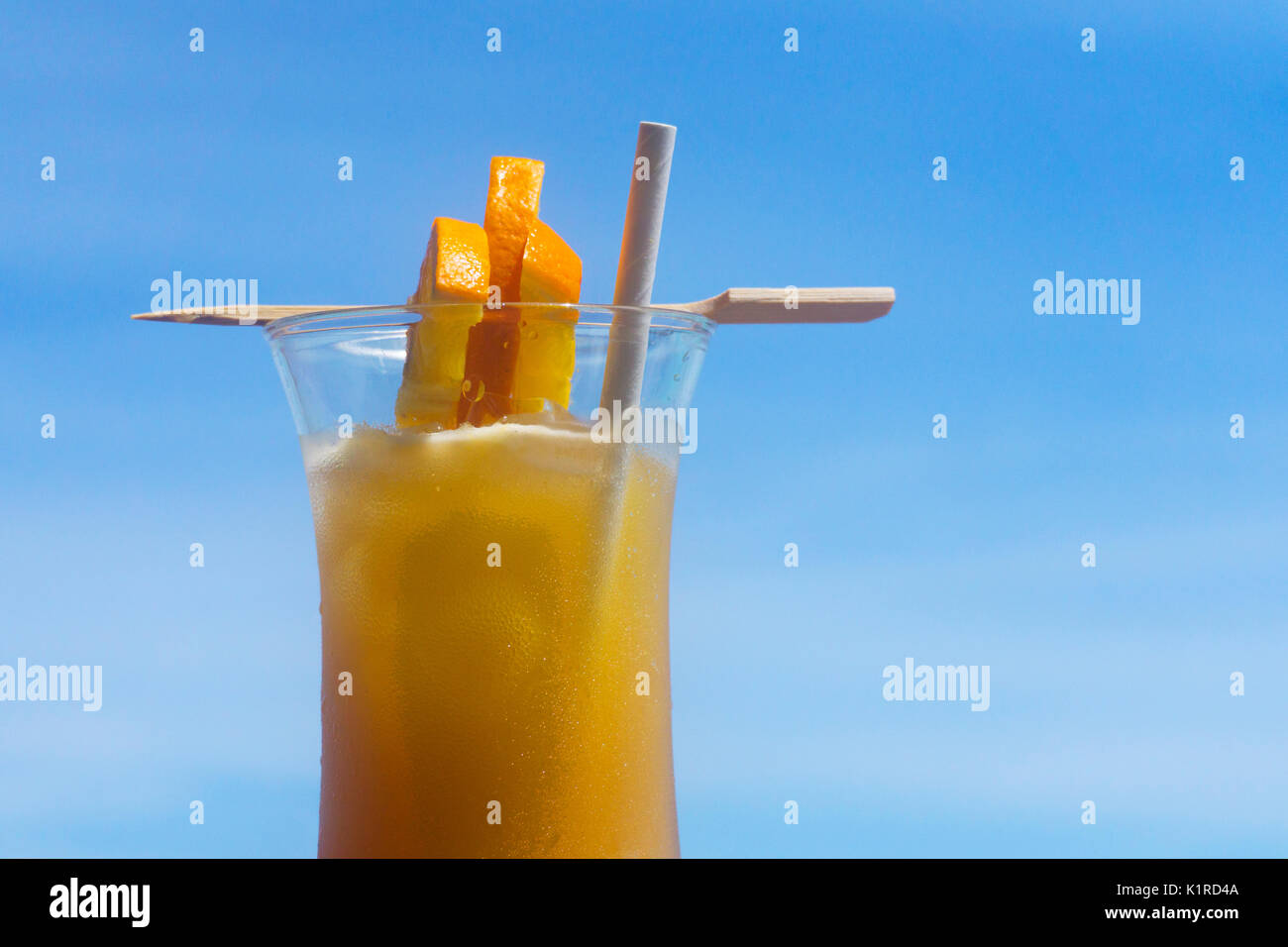 Tropical cocktail with orange against blue sky Stock Photo - Alamy
