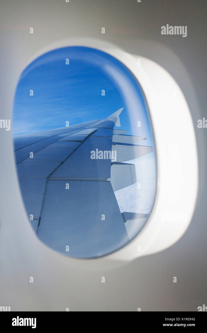 Looking through plane window at airplane wing Stock Photo - Alamy