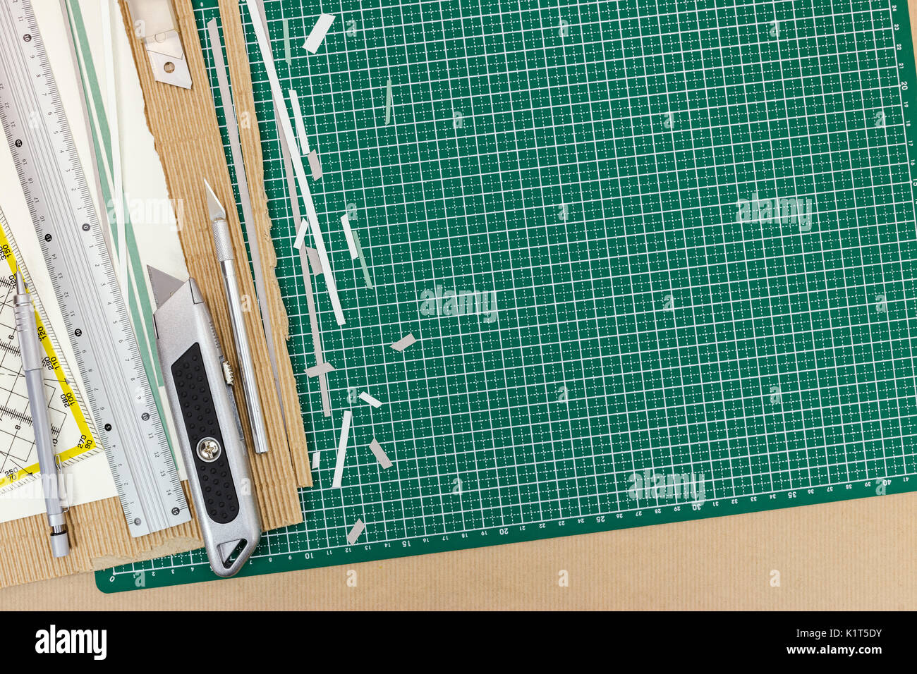 cutting tools on working desk - utility knife, metal ruler with pencil ...