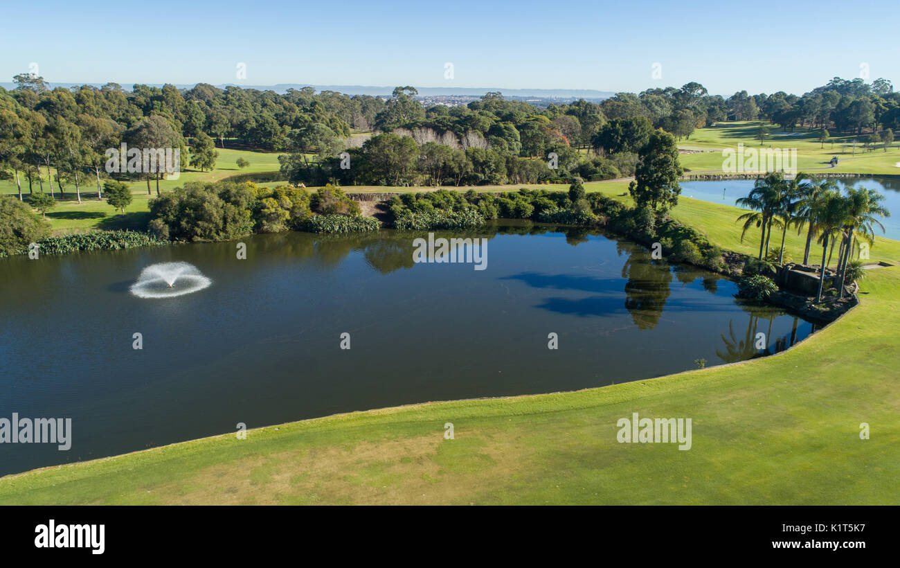 Aerial view of golf course water hazard dam surrounded by tree lined ...