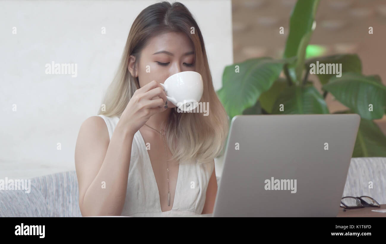 Professional woman working on laptop computer and drinking coffe Stock ...