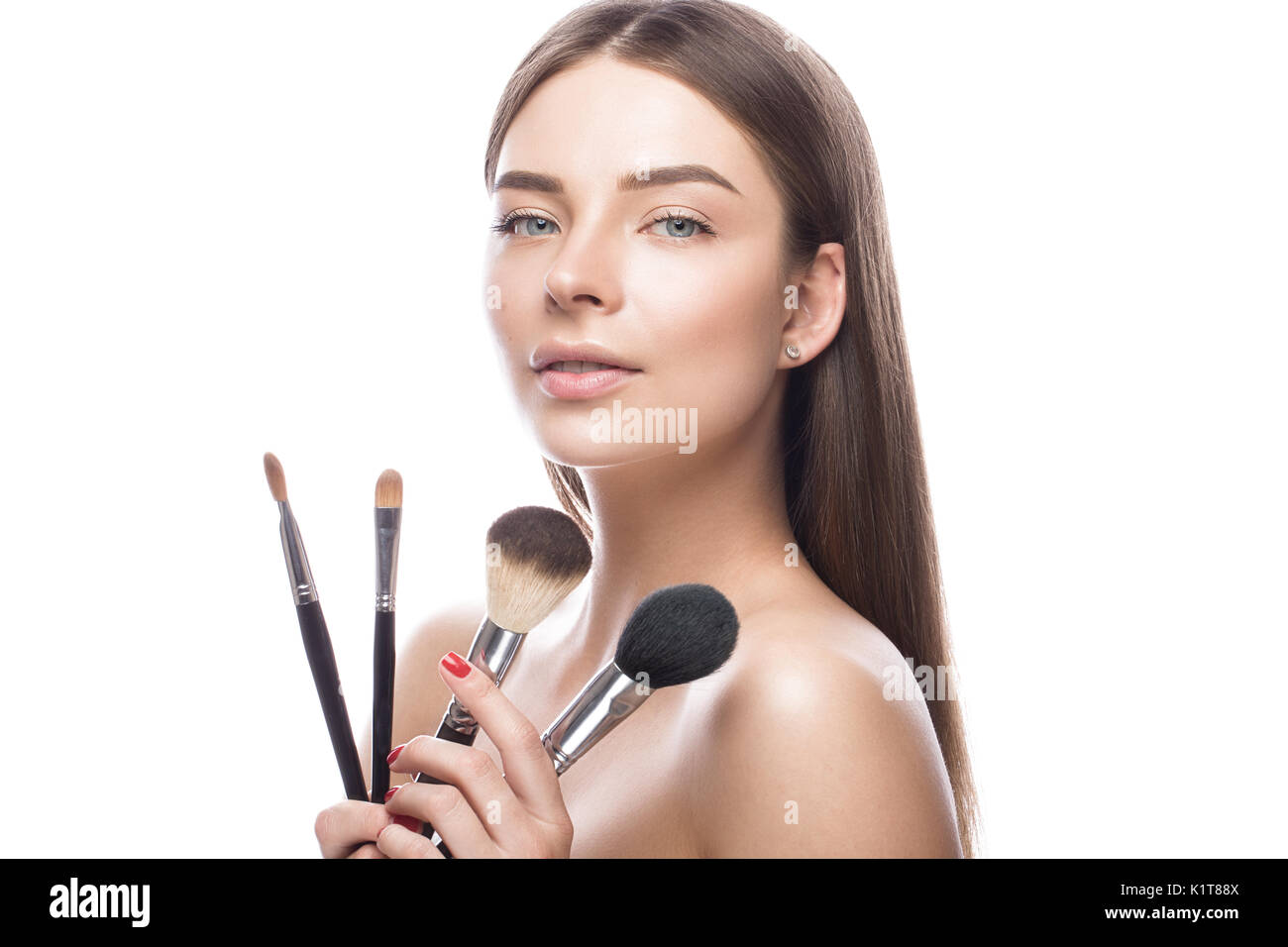 Beautiful young girl with a light natural make-up, brushes for ...