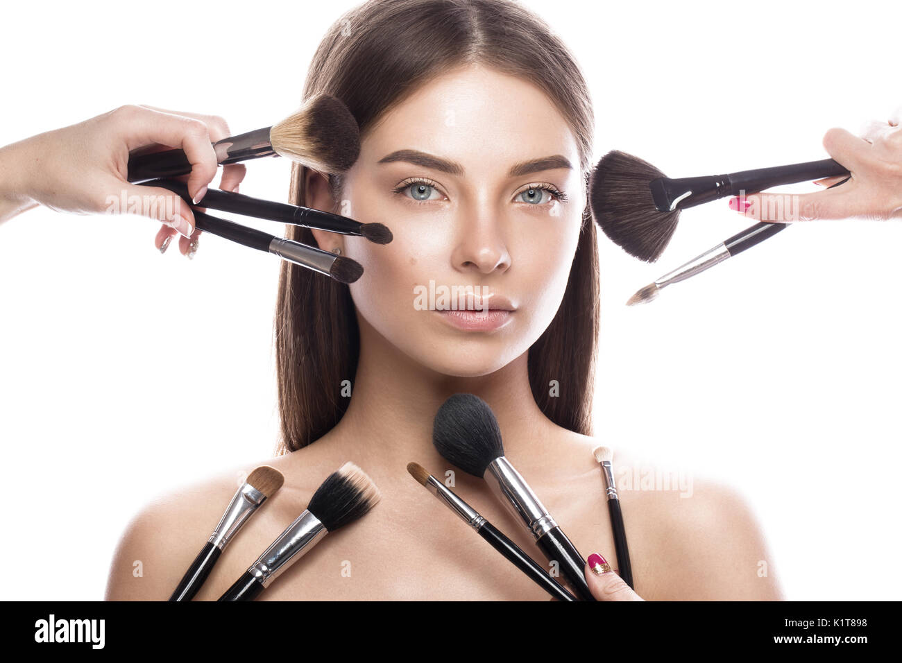 Beautiful young girl with a light natural make-up, brushes for ...