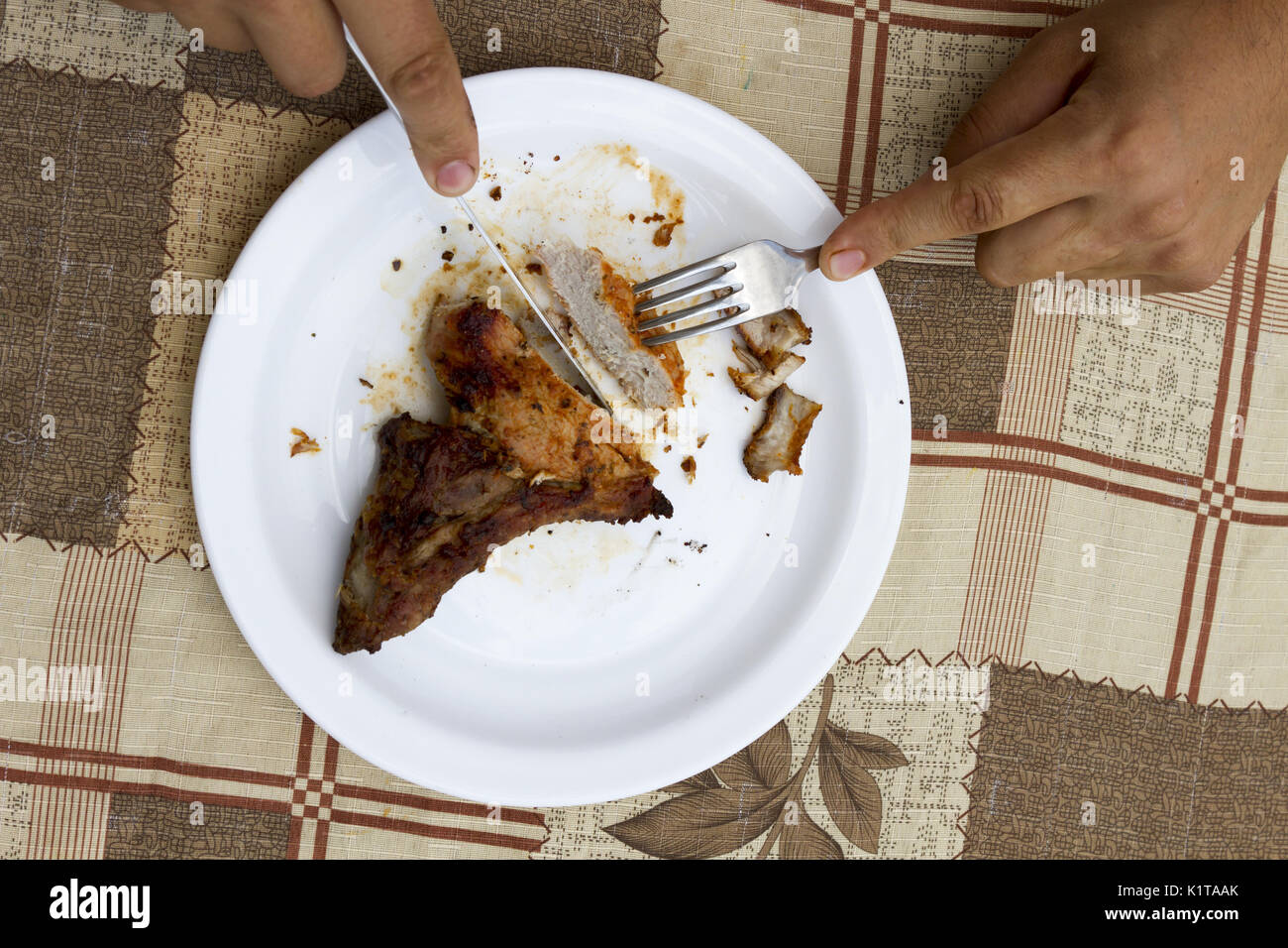 eating stake from plate with fork and knife man hands macro Stock Photo ...