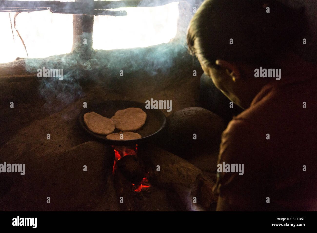 A woman prepares roti (bread) on a wood-fired hearth in Dambulla, Sri ...