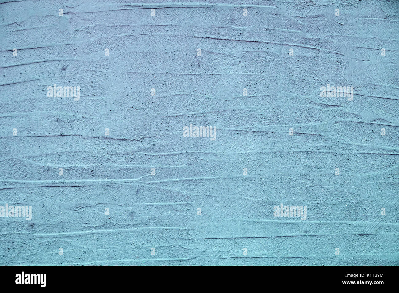 Rough uneven blue wall surface of decorative wavy embossed painted lime ...