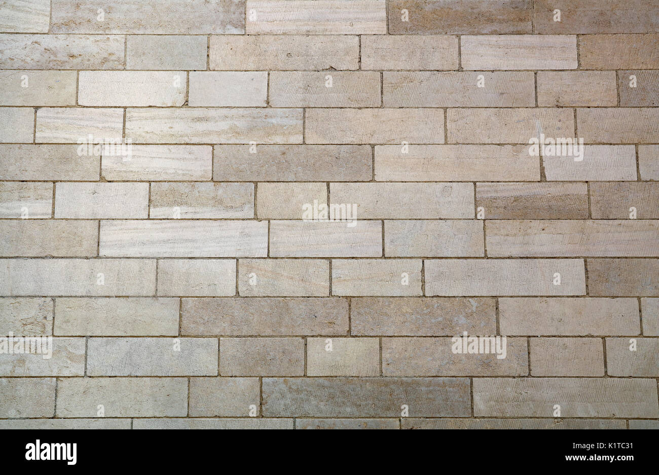 Wall of white and gray adarce travertine stone brick blocks, close up ...