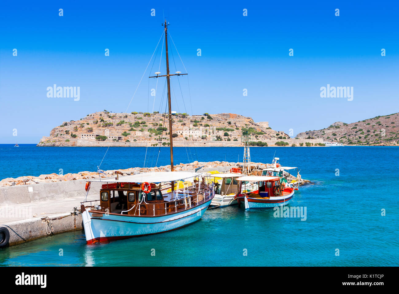 Tourist and fishing boats at the pier of the village of Plaka, near the ...