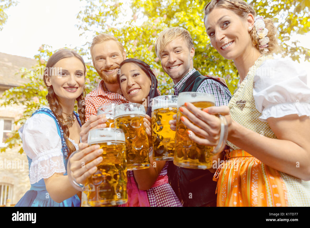 Friends in beer garden with beer glasses Stock Photo - Alamy
