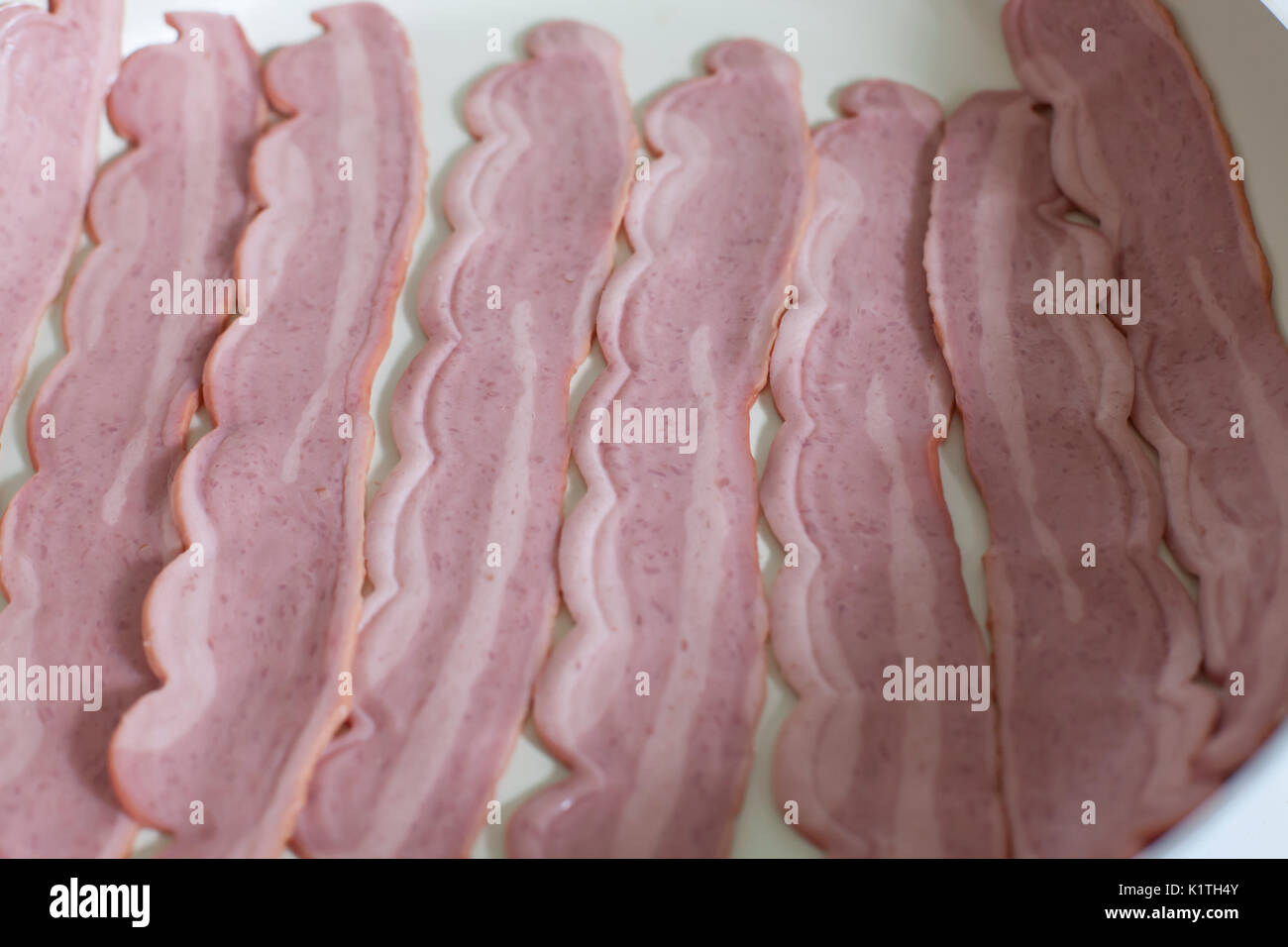 Extreme close up of raw bacon in a pan Stock Photo - Alamy