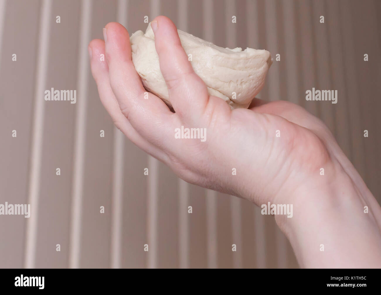 Hand holding a single raw biscuit in the air Stock Photo - Alamy