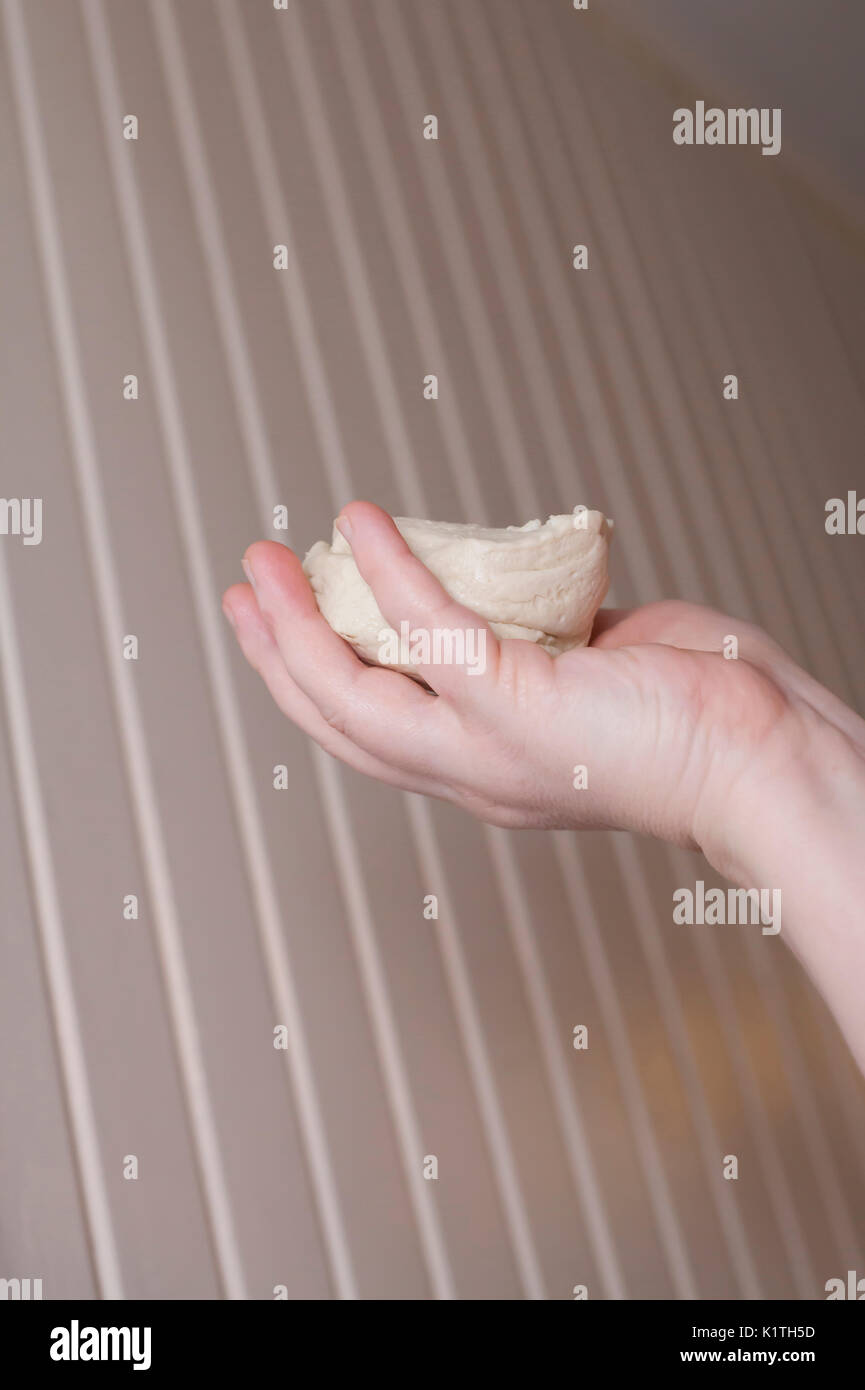 Hand holding a single raw biscuit in the air Stock Photo - Alamy