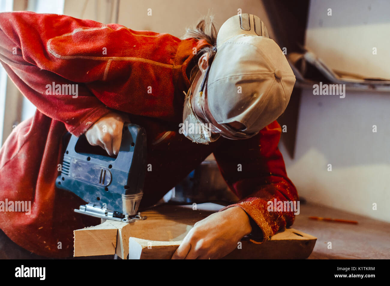 master saws a piece of wood in the workshop Stock Photo - Alamy