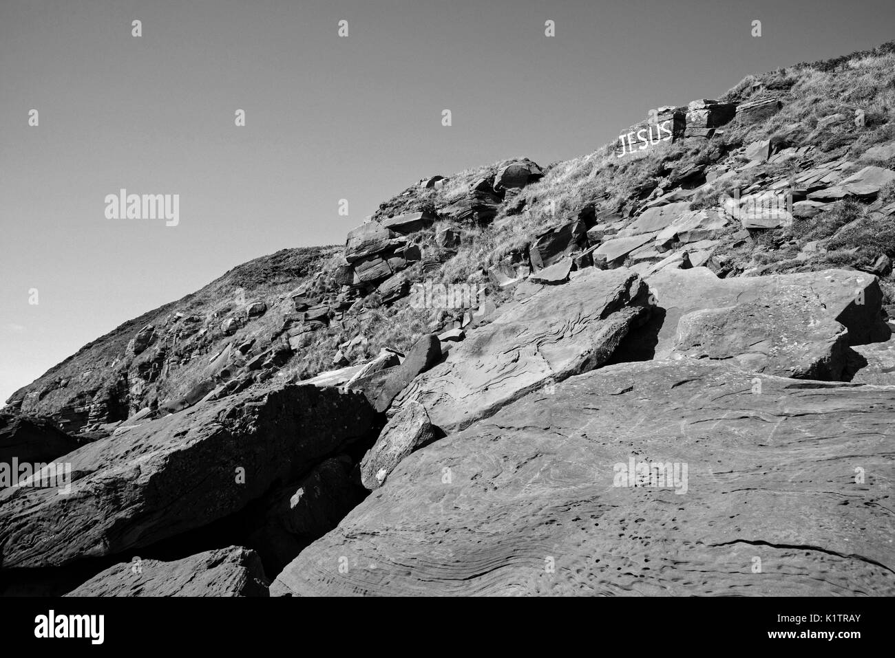 jesus painted in large white letters on st bees cliff Stock Photo - Alamy